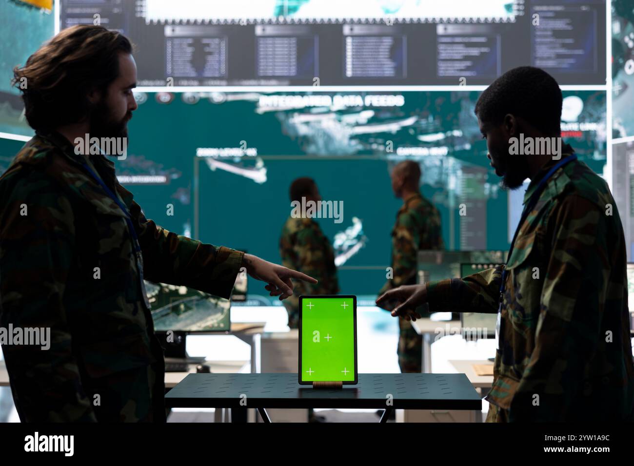 Diverse team of soldiers examine information on a green screen, working ...