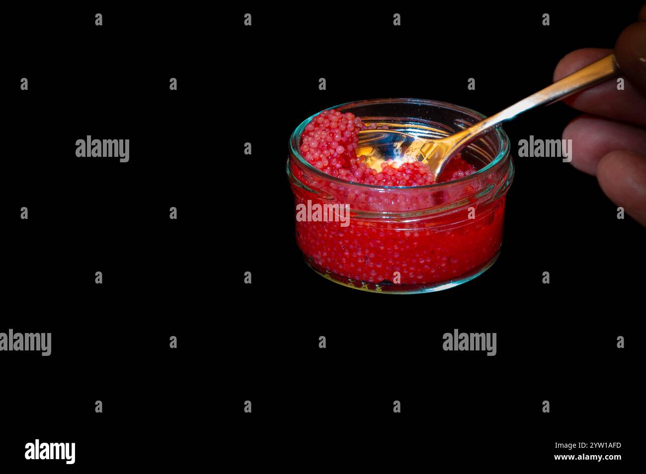 red lumpfish roe in a glass jar and a hand holding a spoon Stock Photo ...