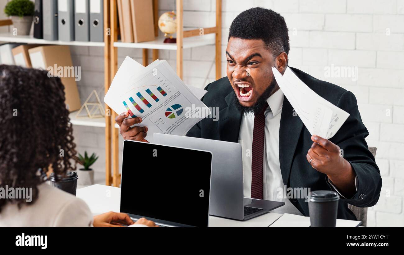 Furious black guy arguing with his female colleague at workplace, empty ...