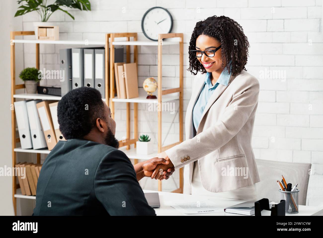 Black hiring manager shaking hands with successful vacancy candidate ...