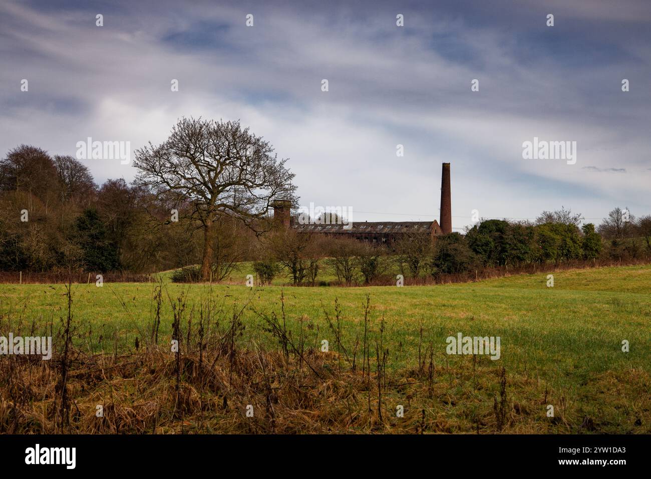 The old chimney of Crimble Mill towers above the surrounding fields ...