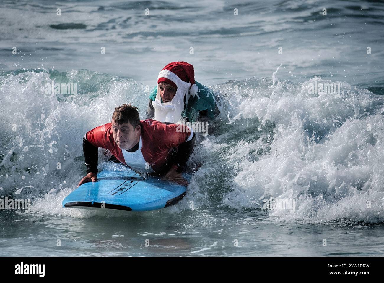 Mark Gabriel, right, dressed as Santa Claus, helps surfer Creighton ...