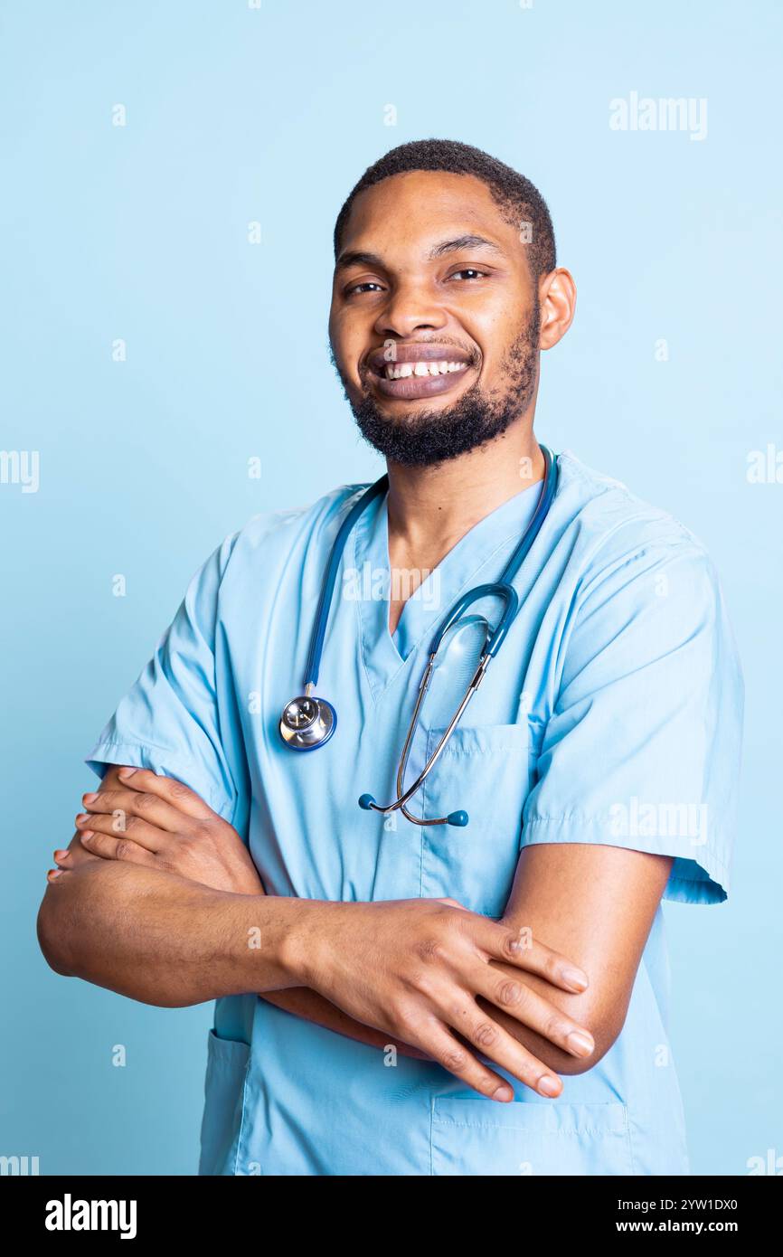 Portrait of friendly professional nurse standing with arms folded ...