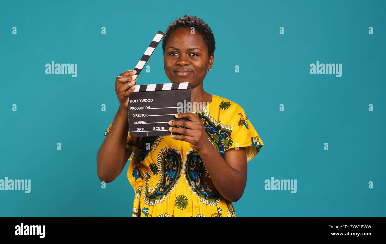 Female film producer using a clapperboard to say action in movie ...