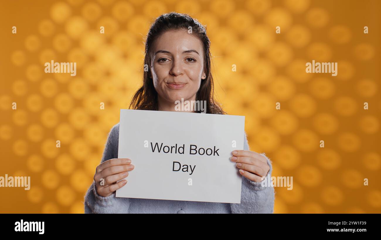 Smiling book club member holding placard with world book day message ...