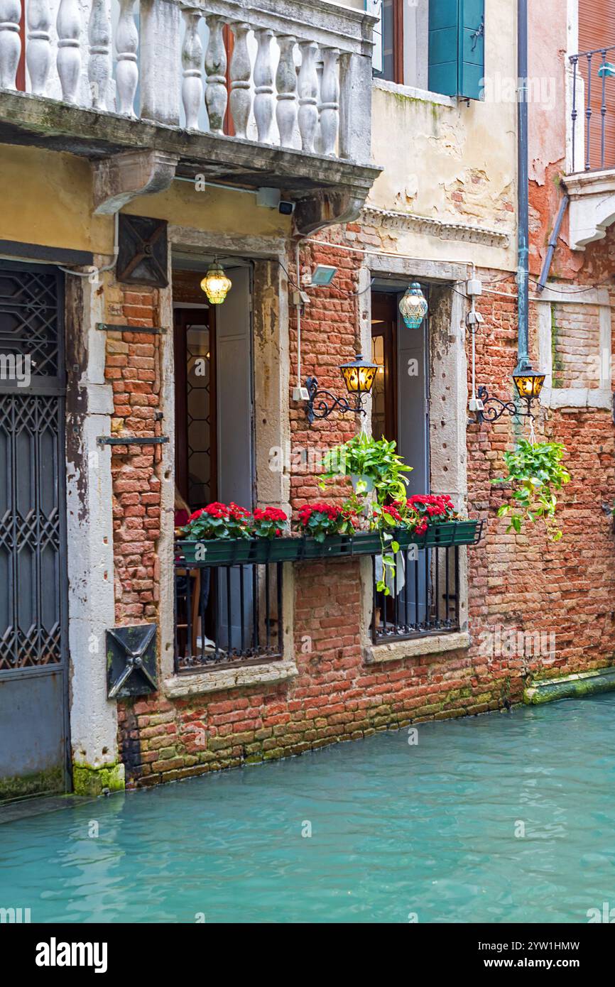 Old local house in Venice with brick wall facade and balconies above ...
