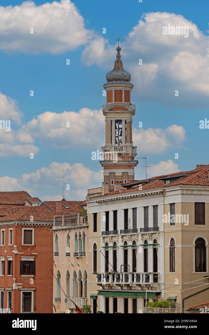 Tall tower on the roof of old Venice house with blue sky clouds in ...