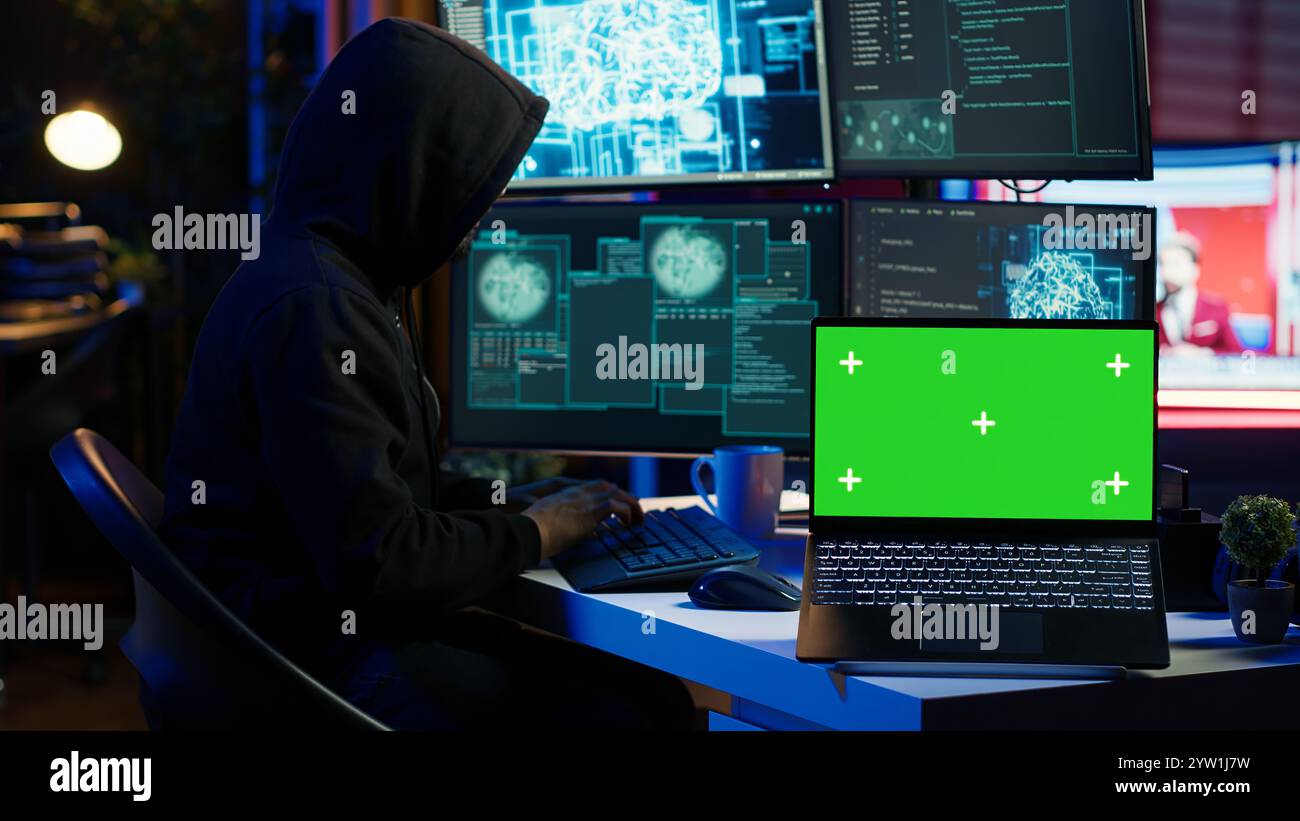 Isolated screen laptop used by cybercriminal in underground hideout to write lines of code and ...