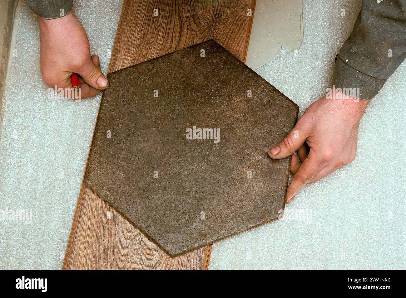 Hands are artistically arranging a hexagonal tile on a soft surface ...
