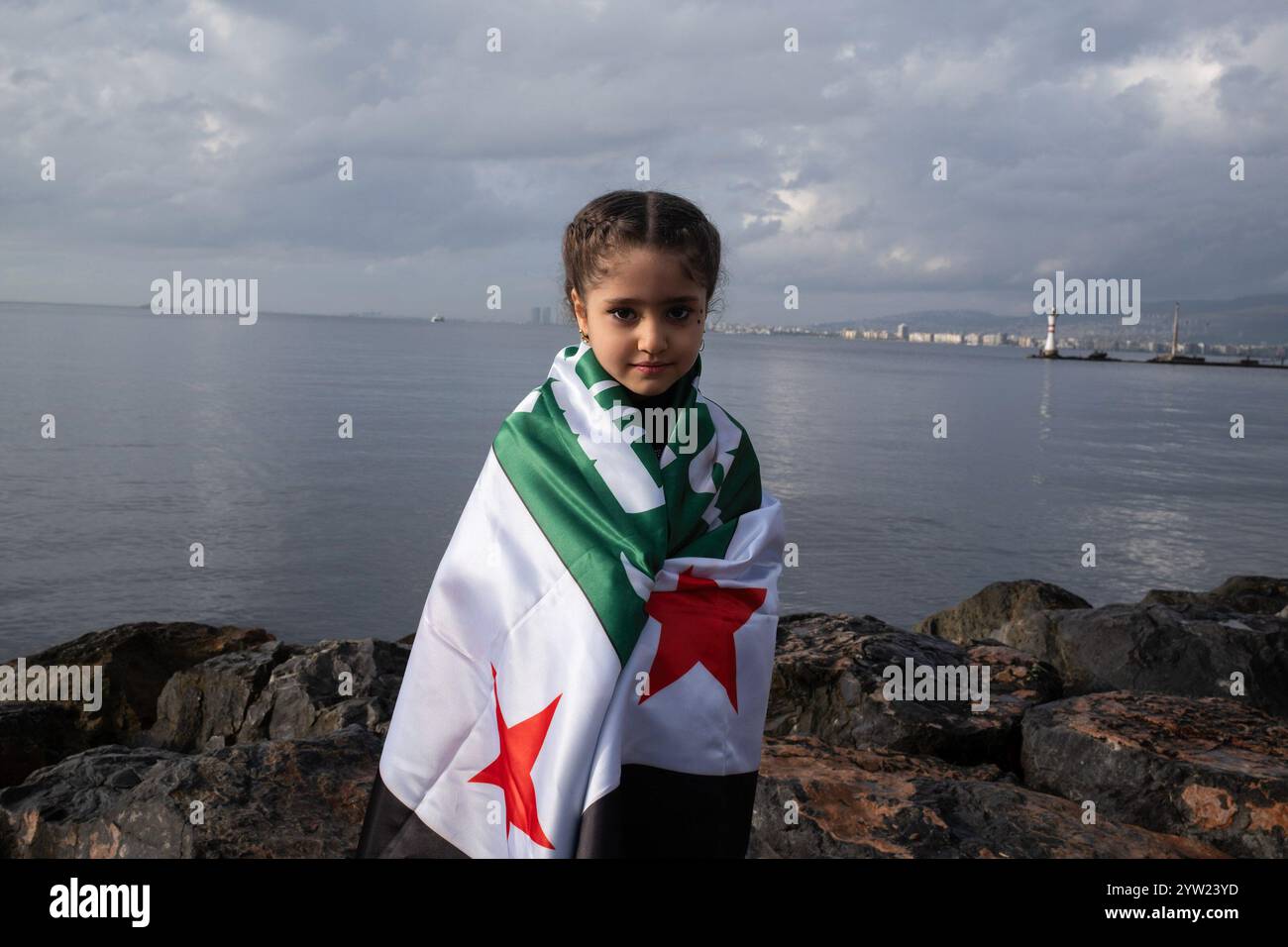 A Syrian girl poses with a flag of the Syrian National Army. The fall ...