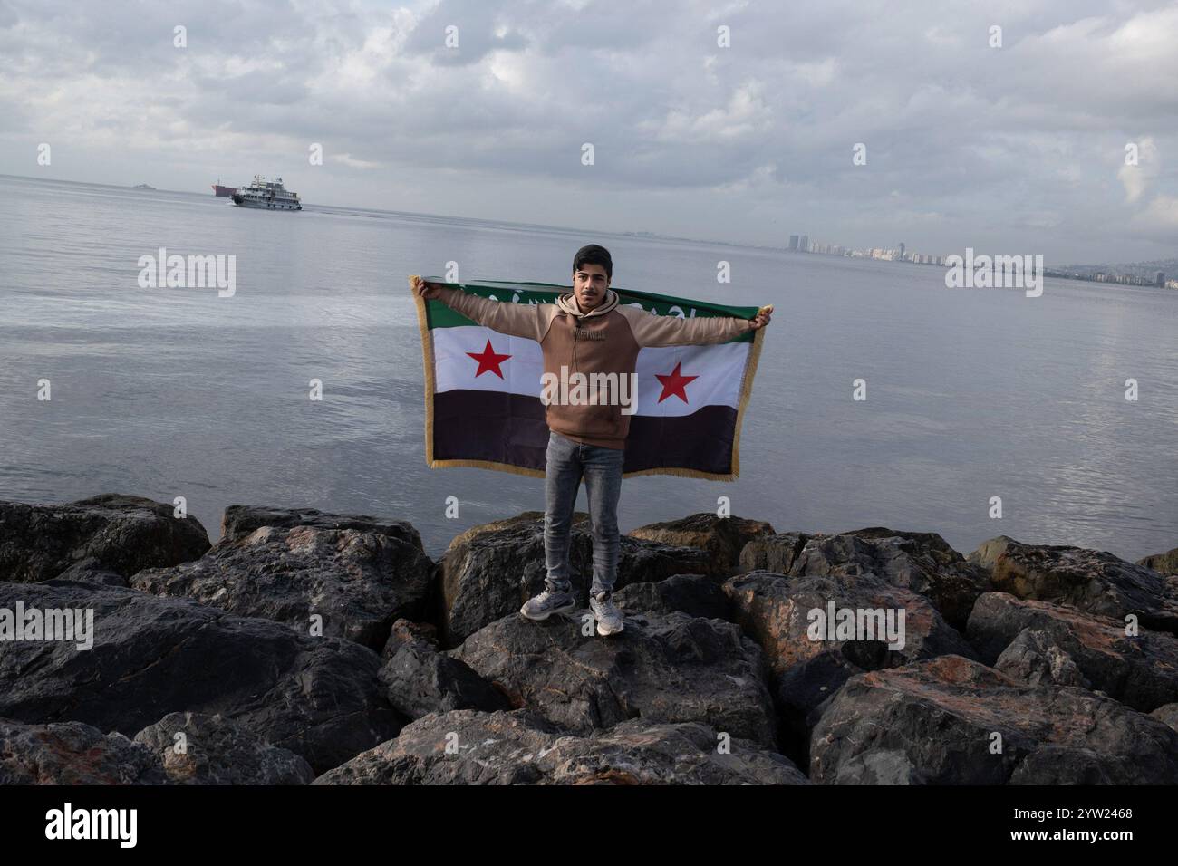Izmir, Turkey. 08th Dec, 2024. A Syrian refugee poses at the beach with ...