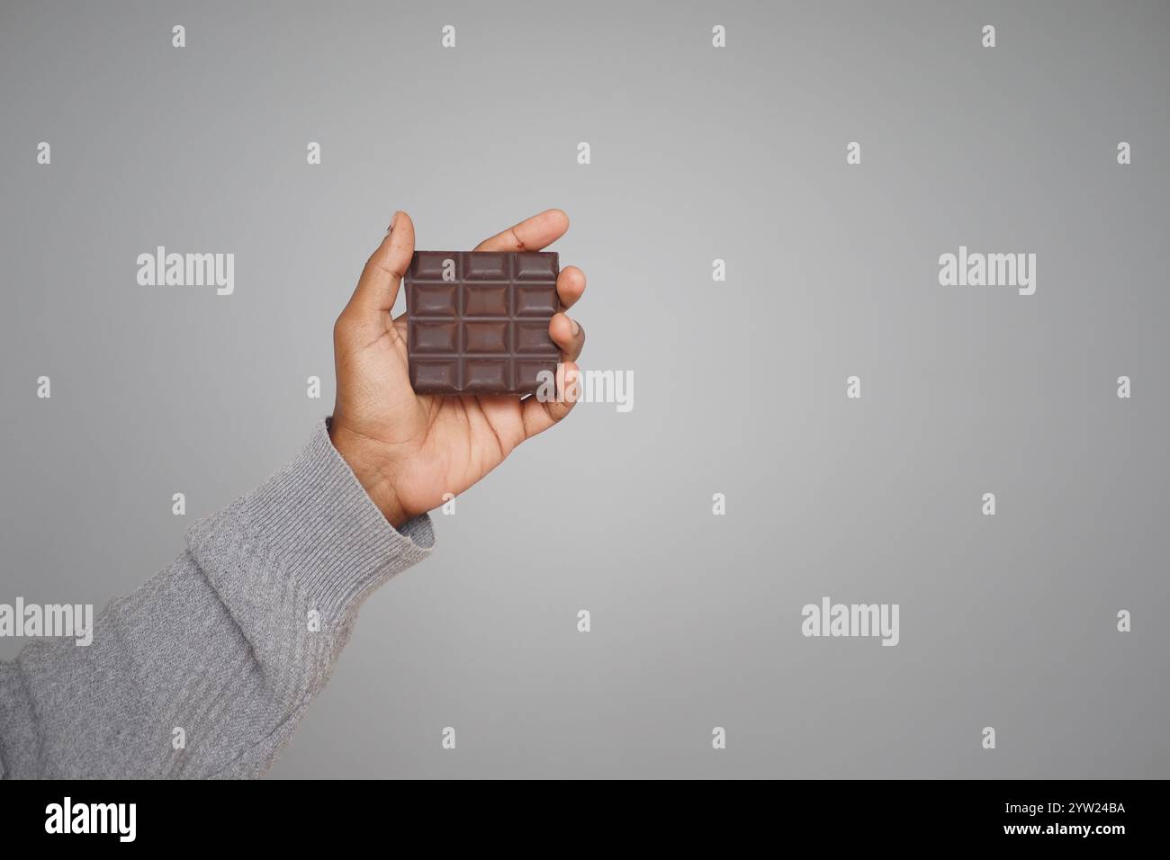 hand holding a dark chocolate candy Stock Photo - Alamy