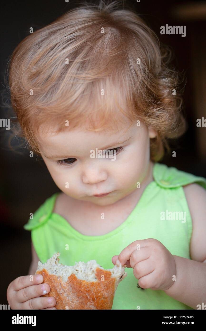 Little boy eating rusk with rusk with raisins. Baby eating bun bread ...
