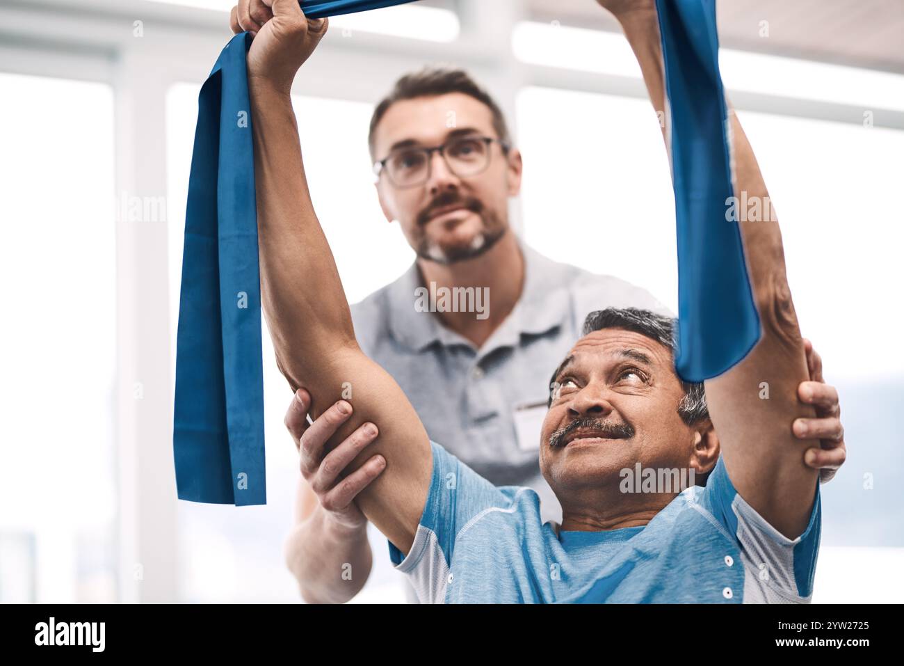 Physical therapy, old man and band for stretching arms at clinic ...