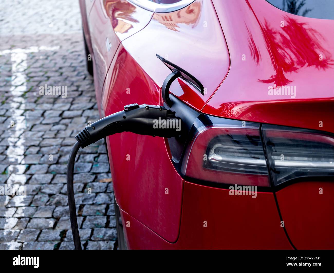 EV car charger handle plugged in, electric vehicle charging cable ...