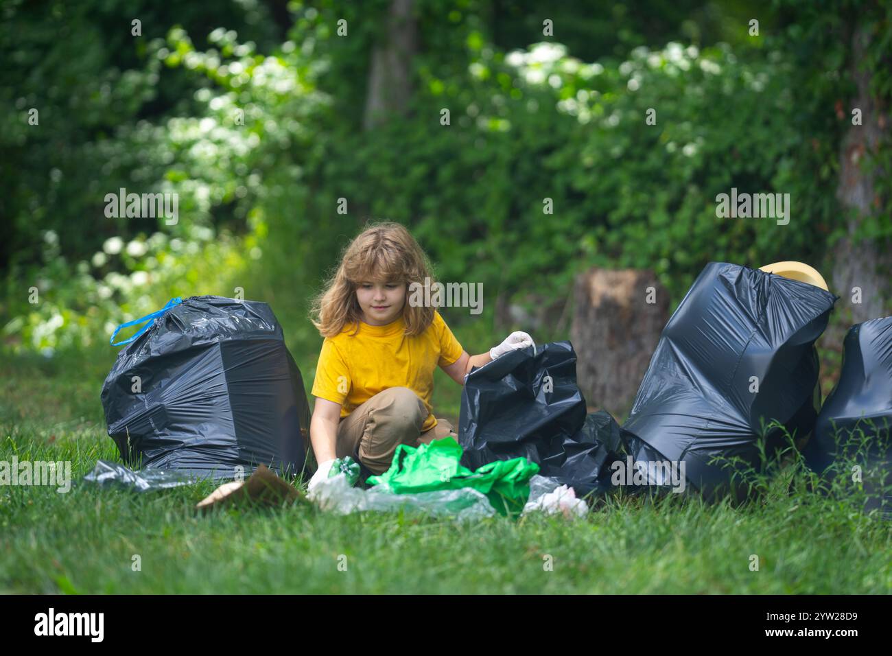 Kid in rubber gloves with trash bag clean up garbage on forest outdoor ...