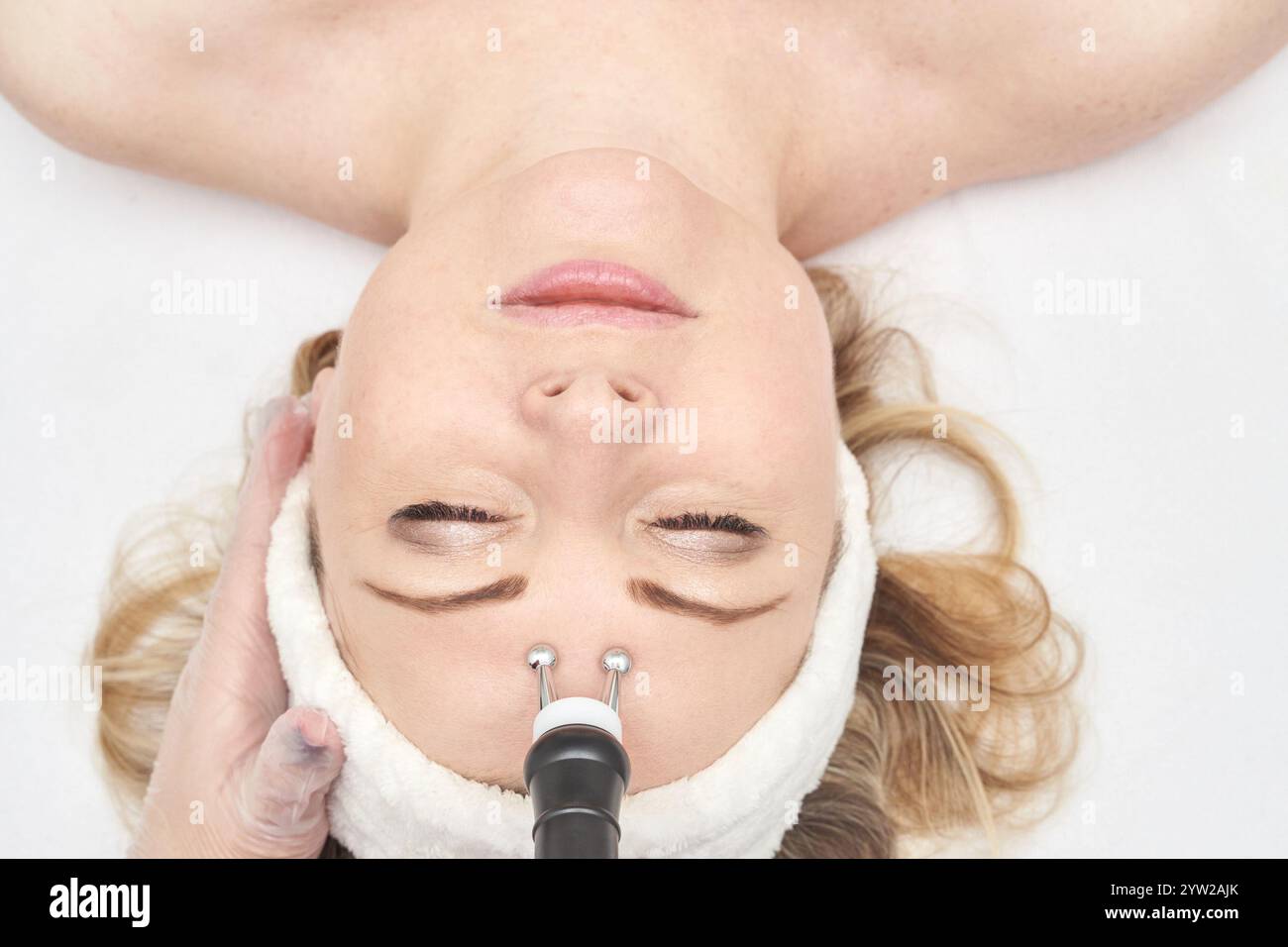 Female caucasian adult receiving facial microcurrent treatment in spa ...