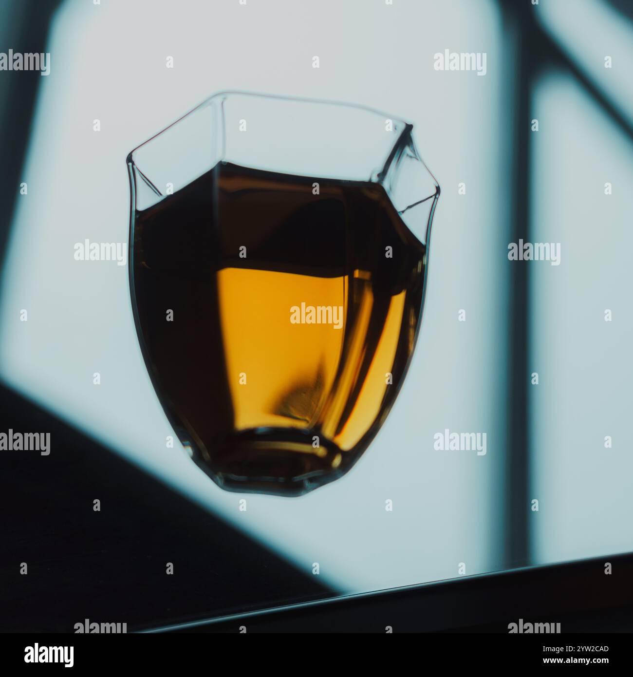 A stylish and elegant glass brimming with a glowing liquid, creating an ...