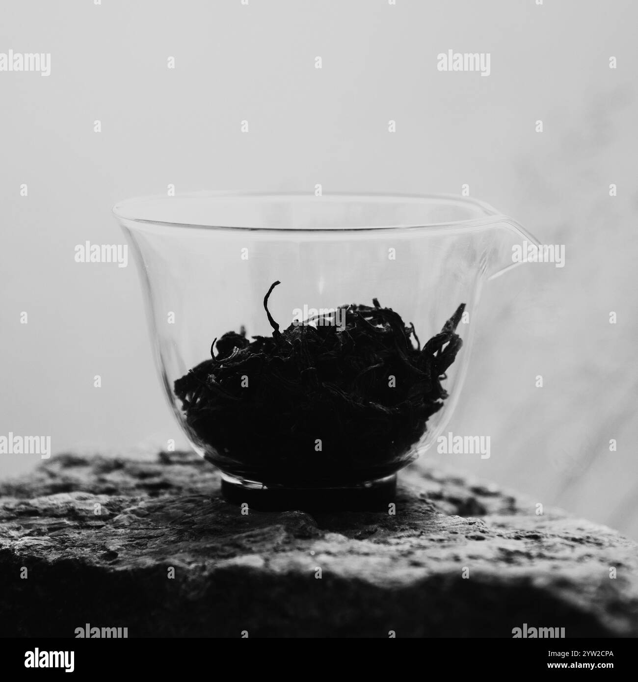 A minimalist black and white photo of tea leaves displayed in a clear ...