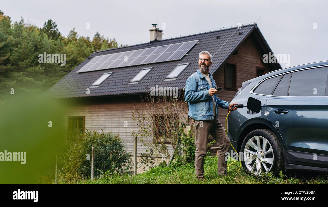 Man charging electric car, plugging the charger into the charging port ...