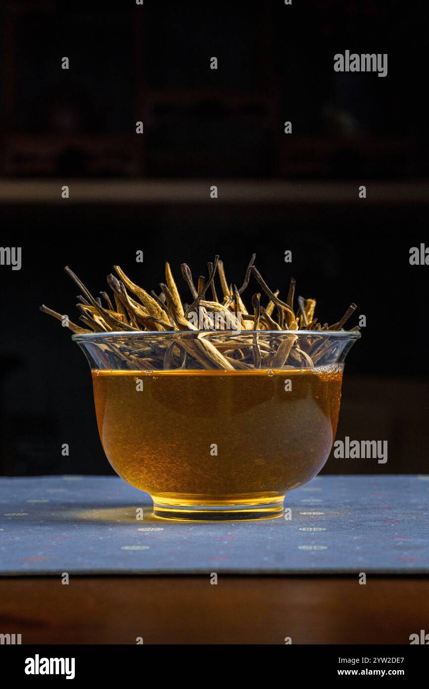 A crafted bowl filled with aromatic herbal tea and twigs showcases the ...