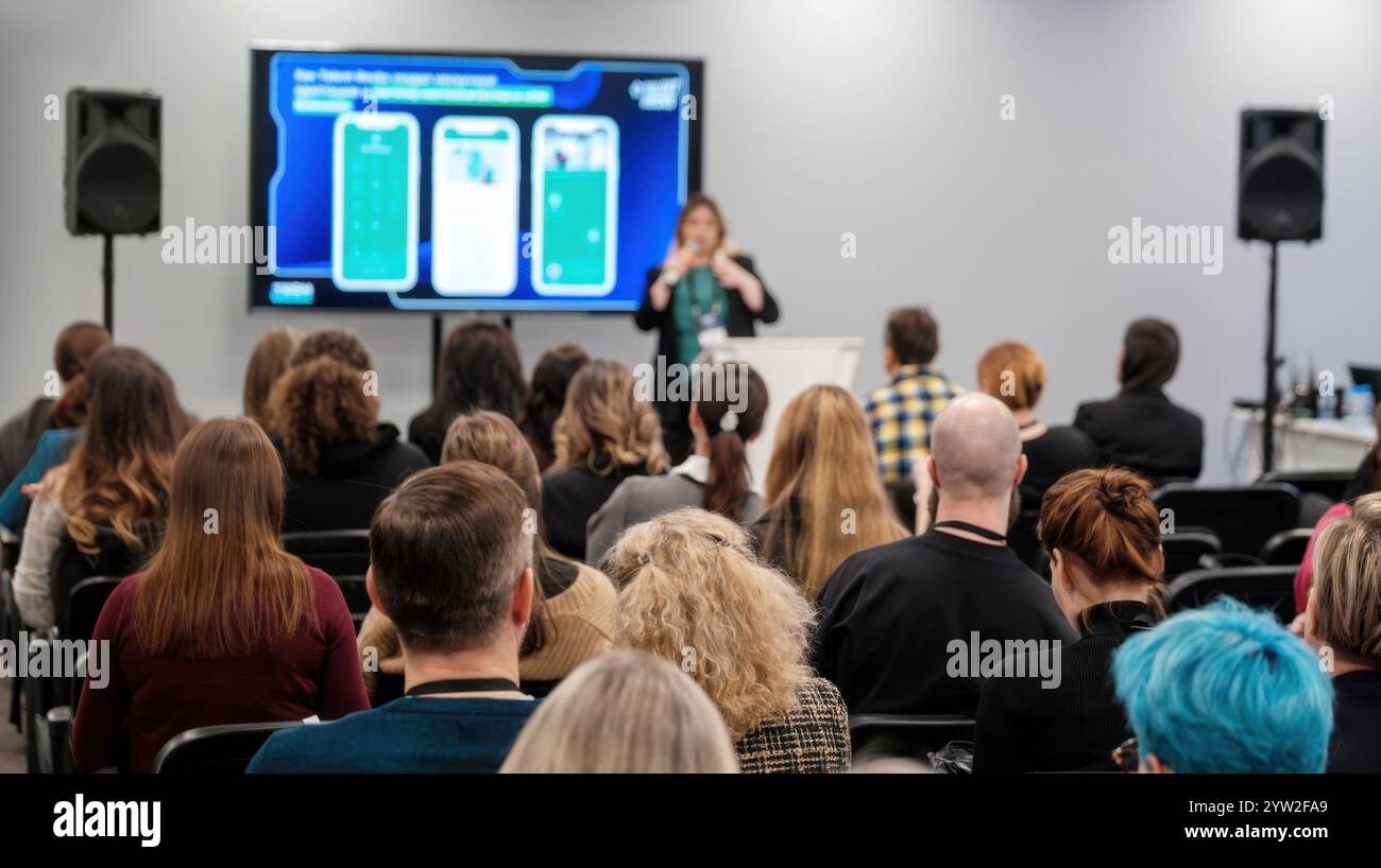 Diverse group of people focused on presentation at a professional event ...