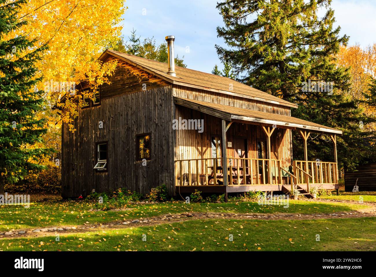 A rustic cabin with a porch and a chimney. The cabin is surrounded by ...