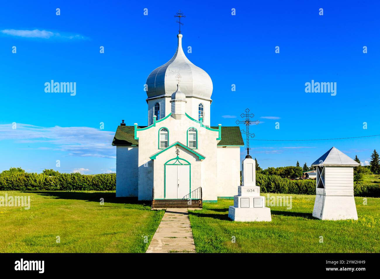 A white church with a green roof and a tall steeple. The church is ...