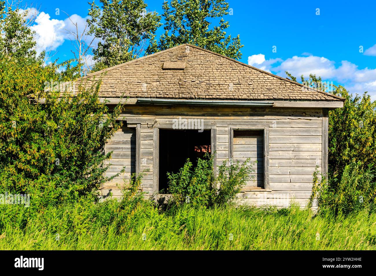 A small, old house with a slanted roof and a window. The house is ...
