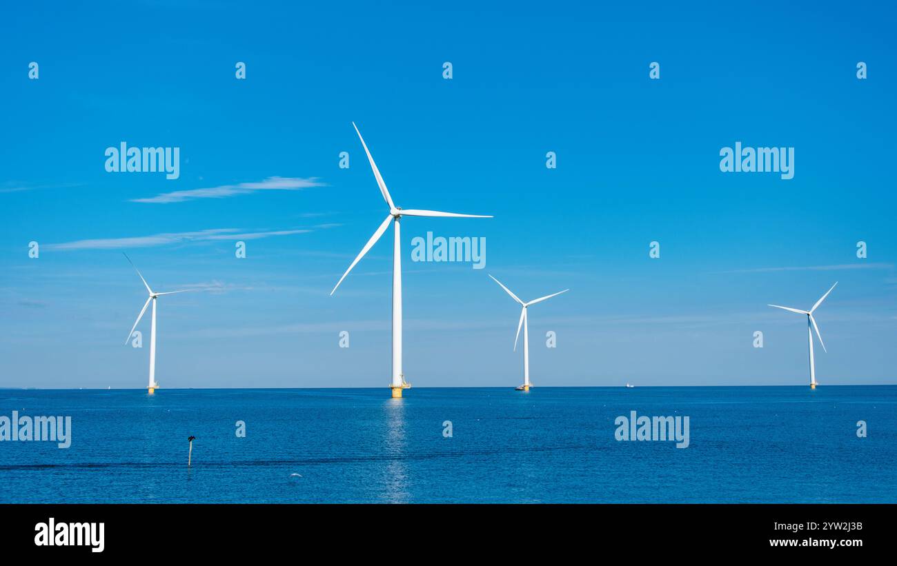 Windmill turbines generating electric green energy with a blue sky ...