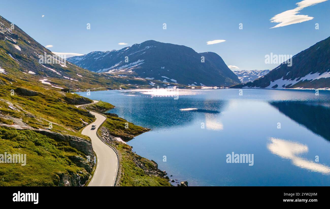 A single car winds its way through the majestic Norwegian landscape, a ...