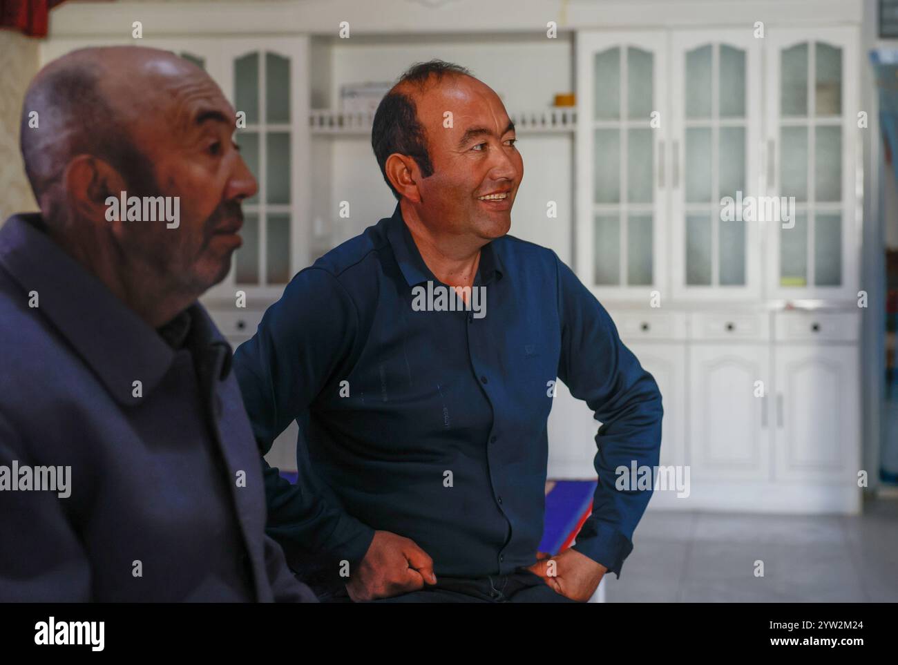 (241209) -- MINFENG, Dec. 9, 2024 (Xinhua) -- Memet Metseyit (R) talks ...