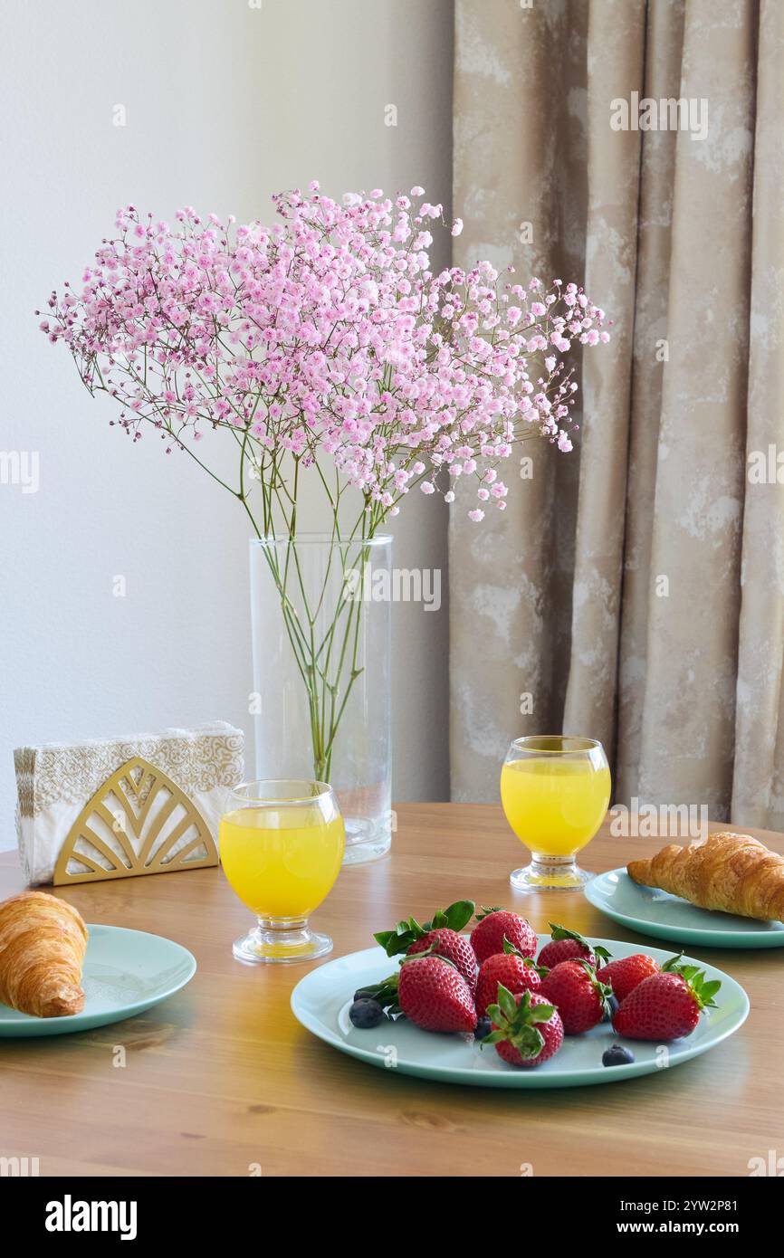 An Elegant Breakfast Table Setting Featuring Beautiful Flowers and a Variety of Fresh Fruit ...