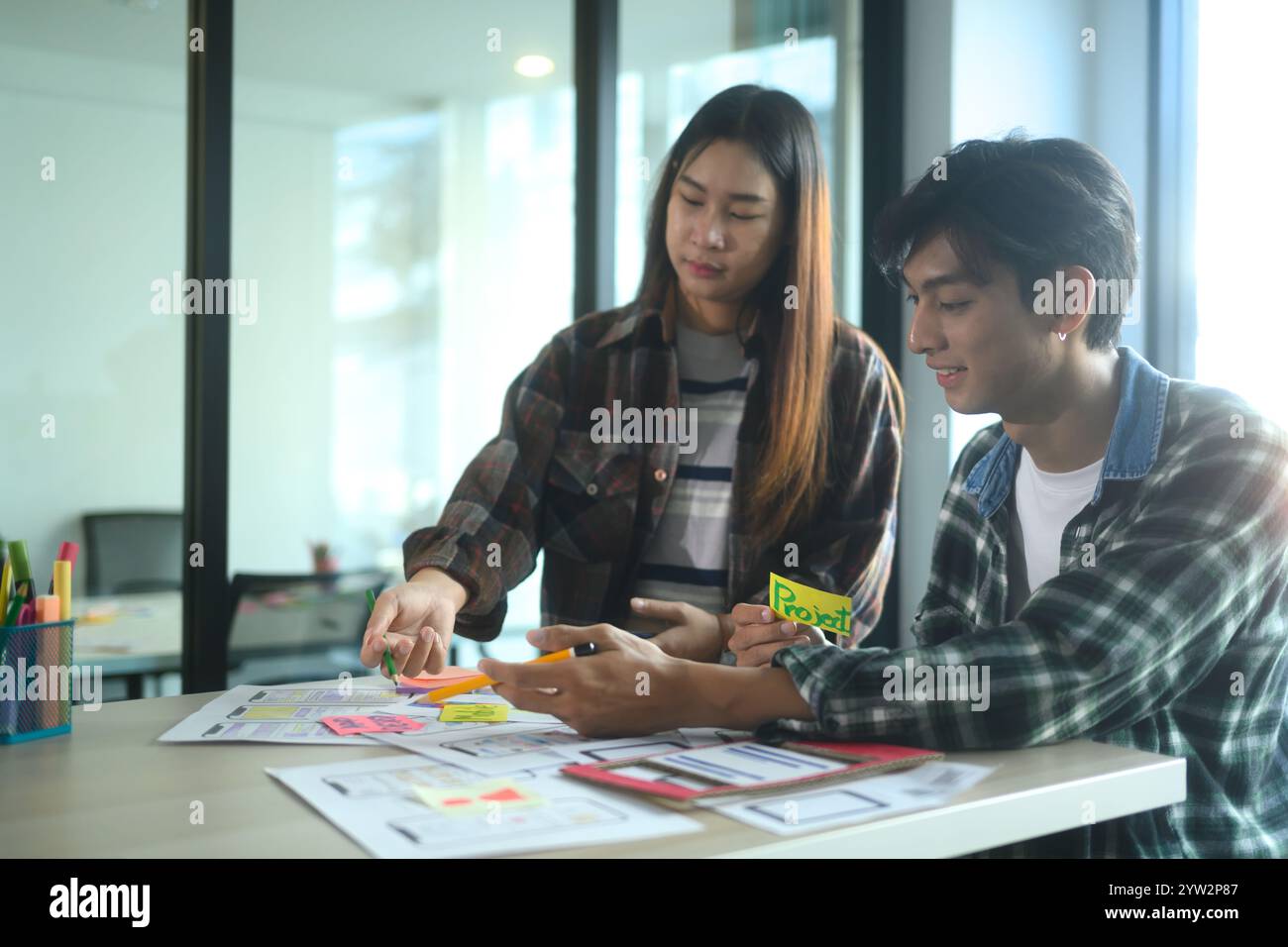 Two colleagues collaborating on app design wireframes and using ...