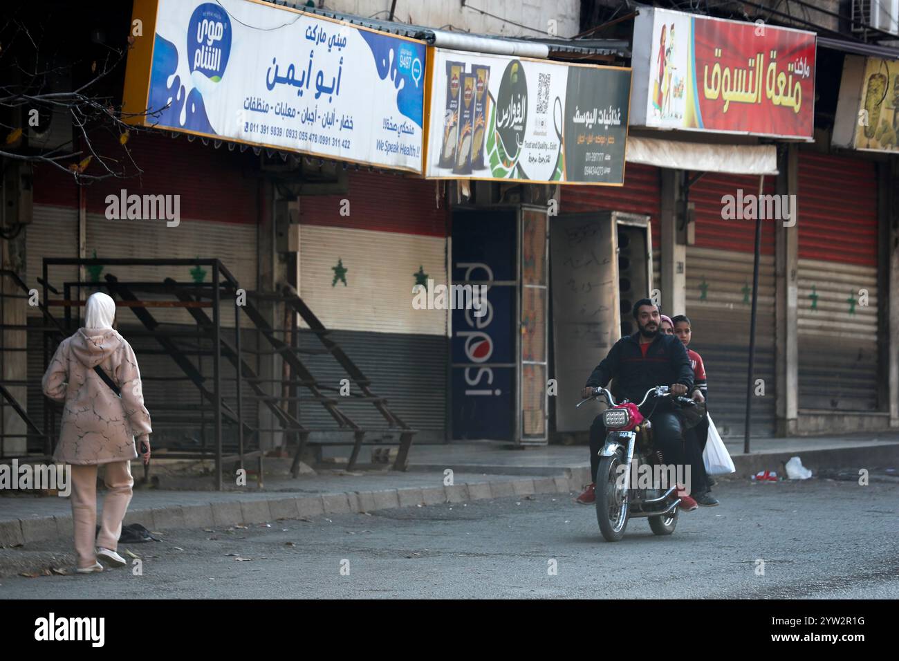 A man rides a motorcycle past closed shops in the aftermath of Sunday's ...