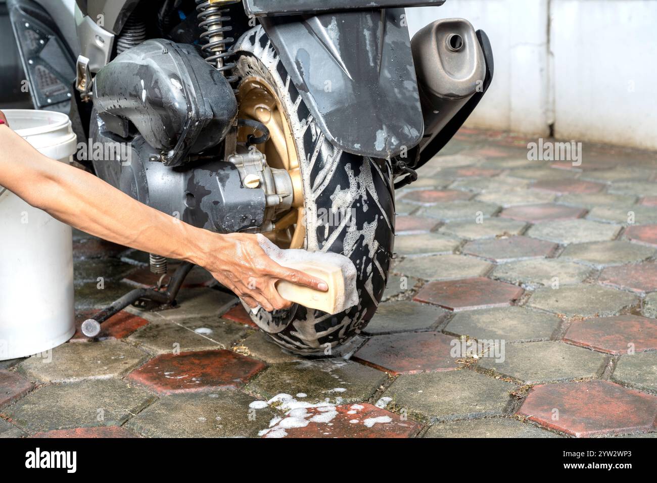 Professional worker hand washing the motorcycle with cleaning foam ...