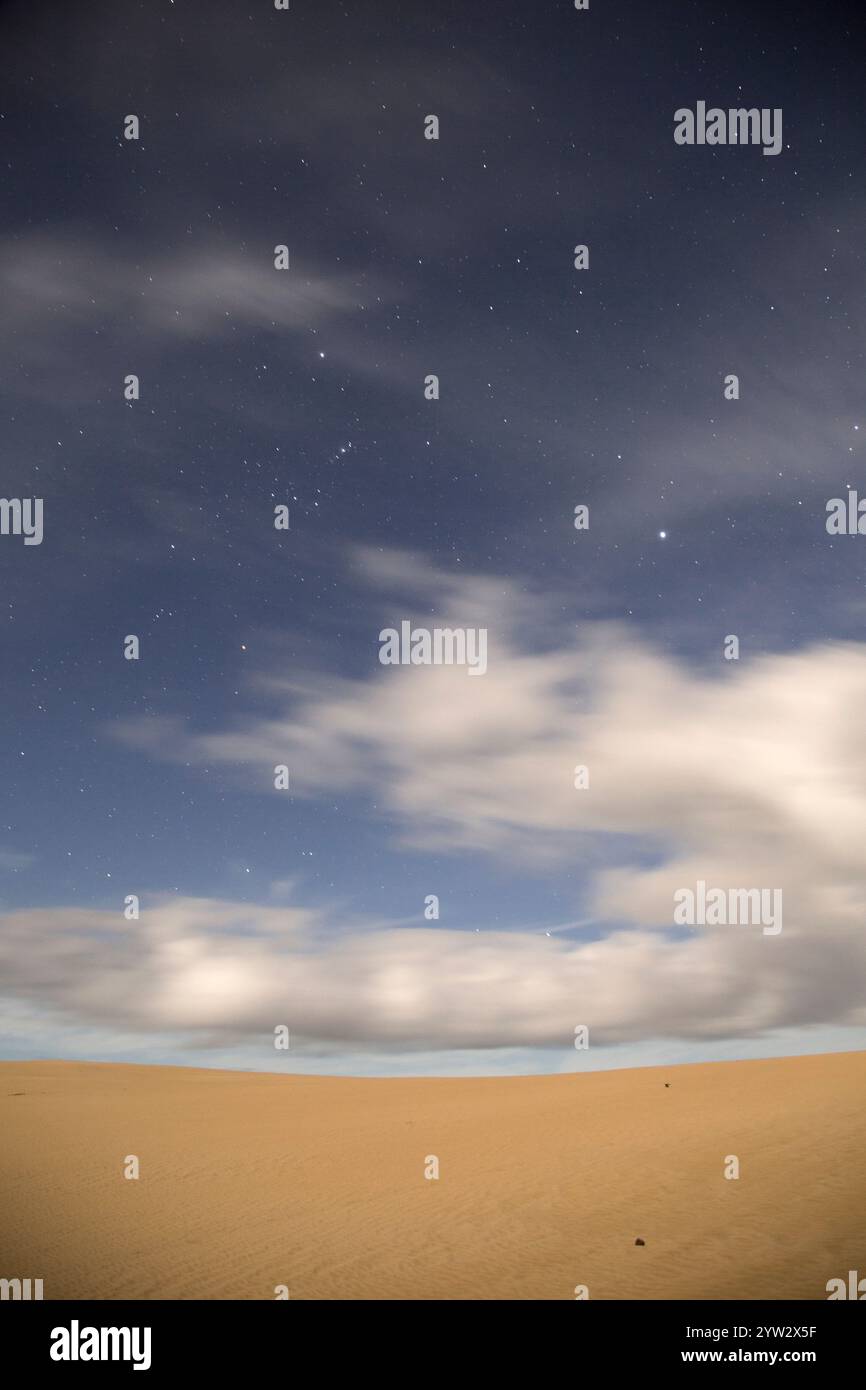 Starry night sky above a smooth desert landscape under a blanket of ...