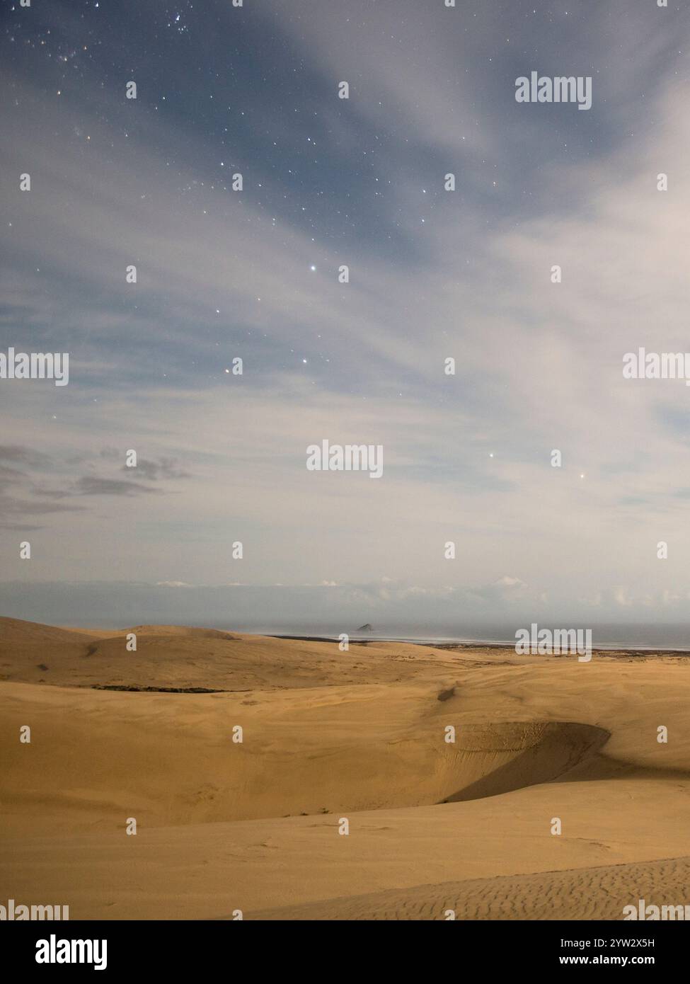 Starry night sky over smooth desert dunes under a twilight gradient, Te ...