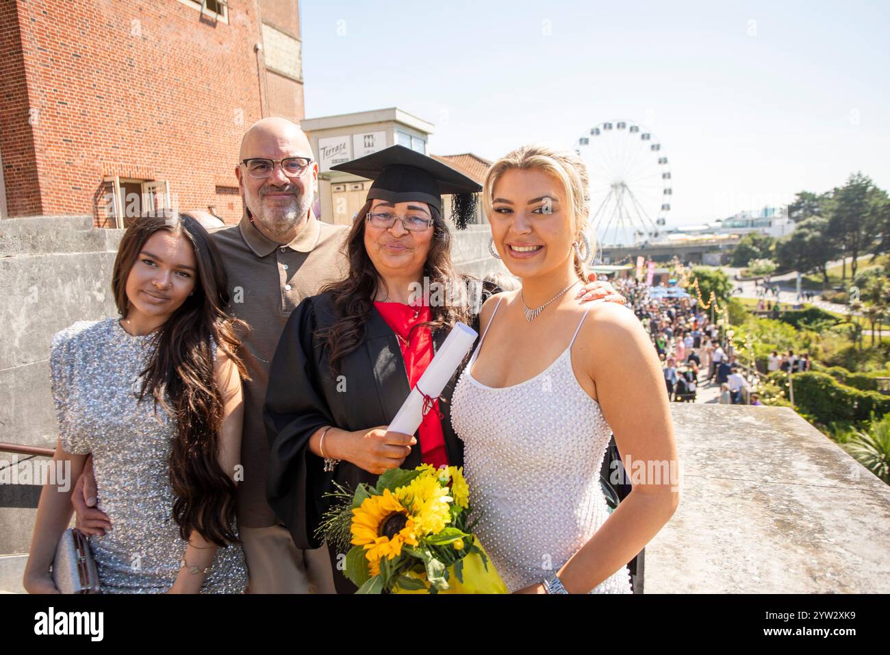 Family celebrating a graduation ceremony with a smiling woman in cap ...