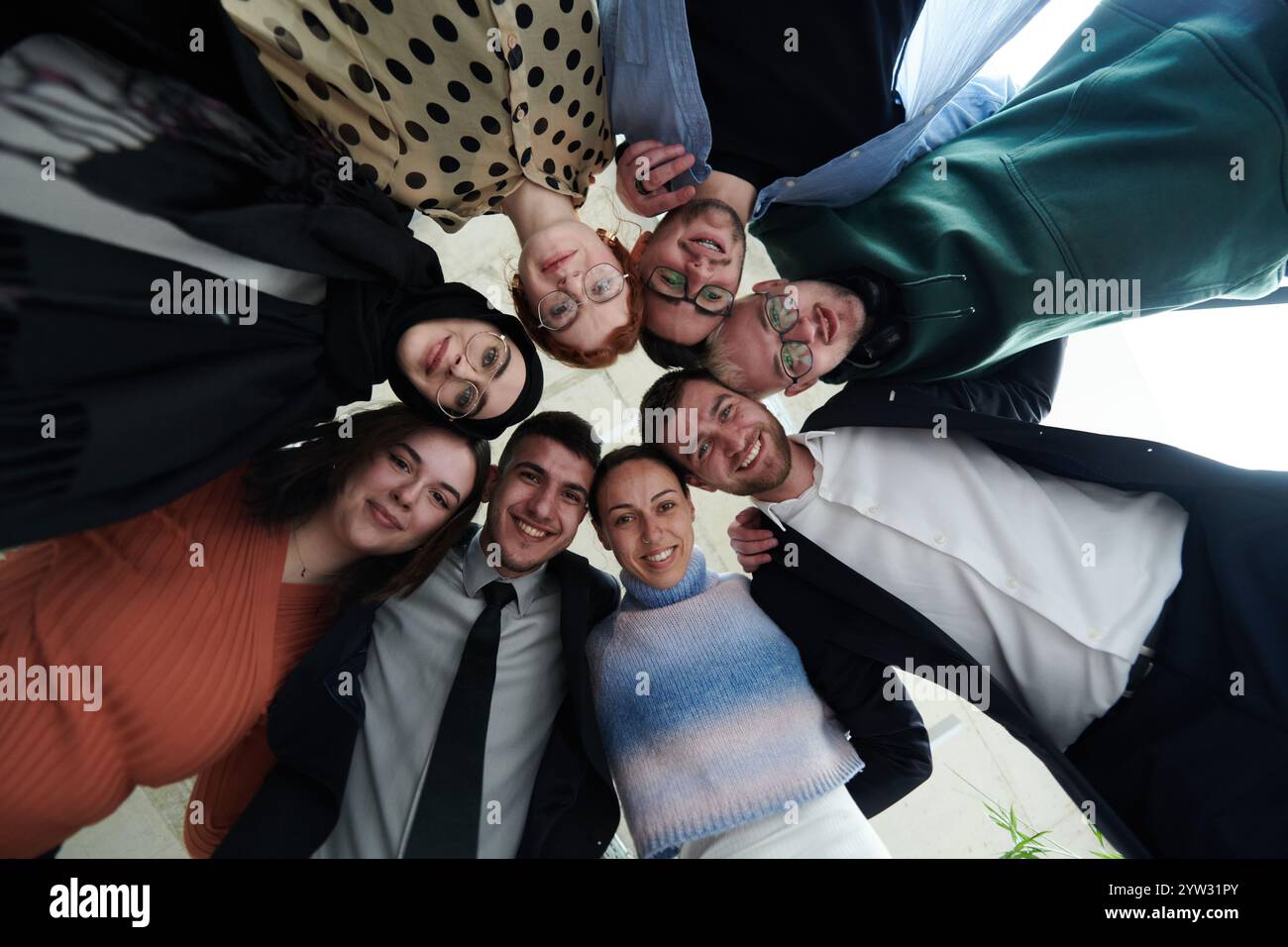 A diverse group of business professionals standing together in a ...