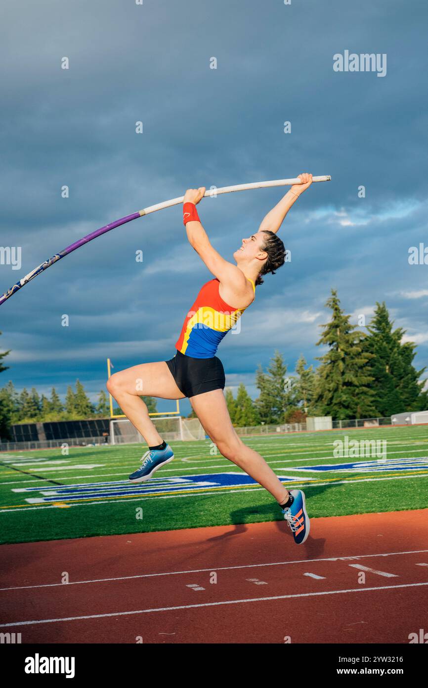 Female pole vaulter in mid-action during a track and field competition ...