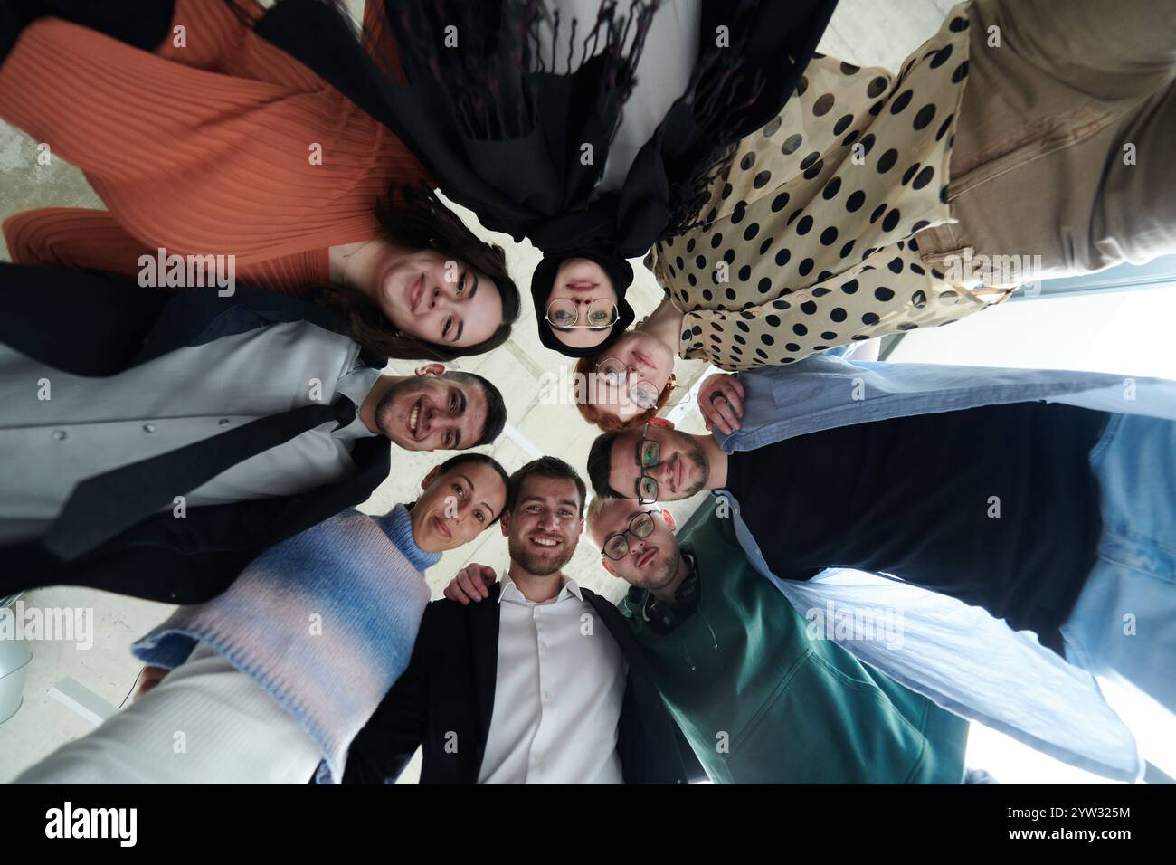 A diverse group of business professionals standing together in a ...