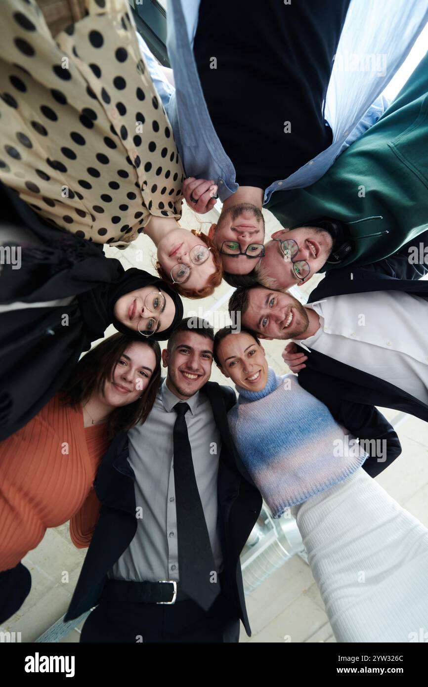 A diverse group of business professionals standing together in a ...