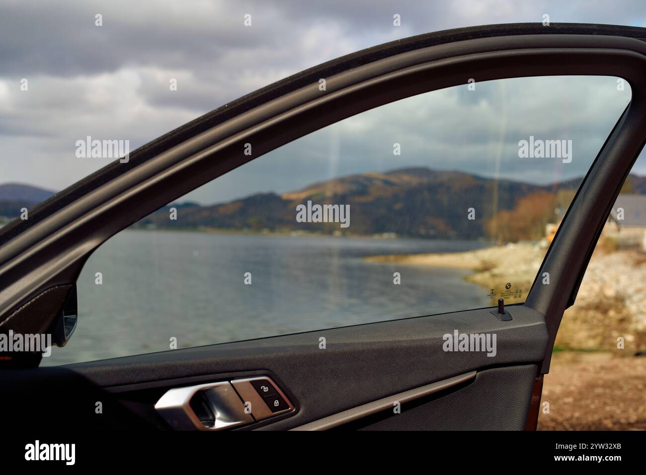 Car door open with a scenic view of a tranquil lake and mountains in ...