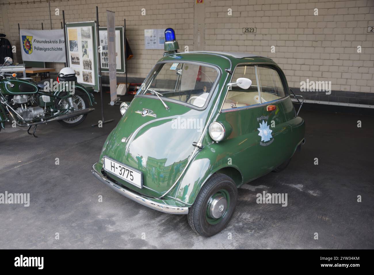 Green vintage tricycle with police emblem and blue lights at a ...