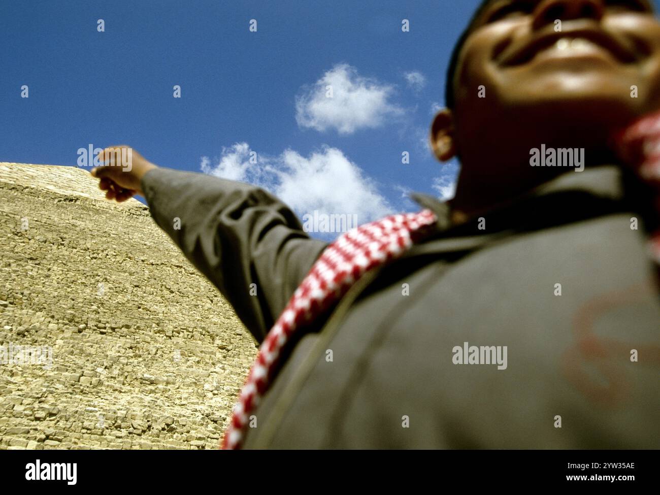 Young local pointing at the top of the pyramid of Khafre, Giza plateau ...