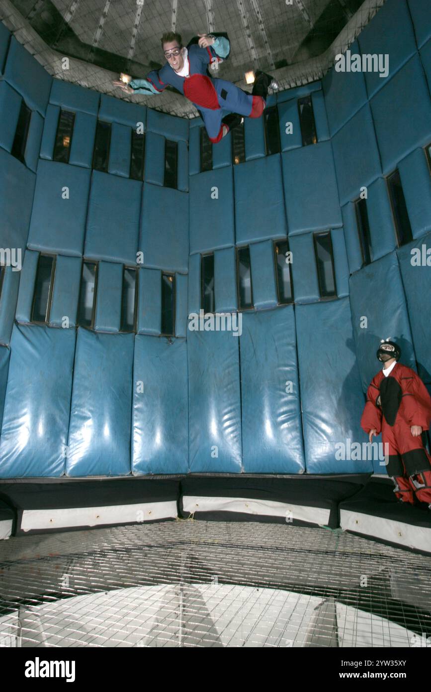 Two indoor skydiving instructors during a flight session in a wind ...