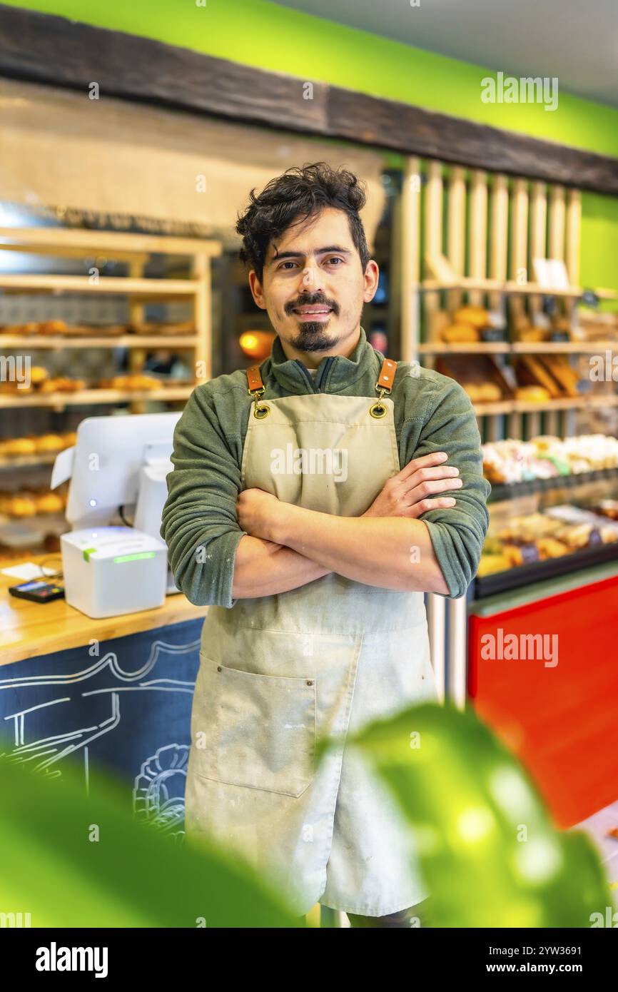 Vertical portrait of a latin male artisan baker standing proud in the ...