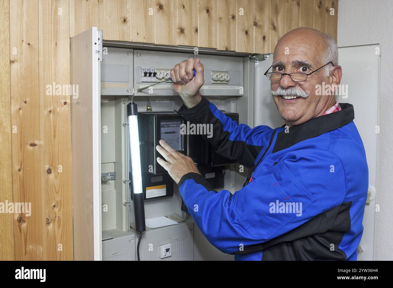 An electrician works on the fuse box, electricity meter, check ...
