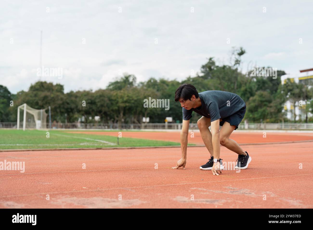 Athlete preparing to sprint sports track action outdoor stadium low ...